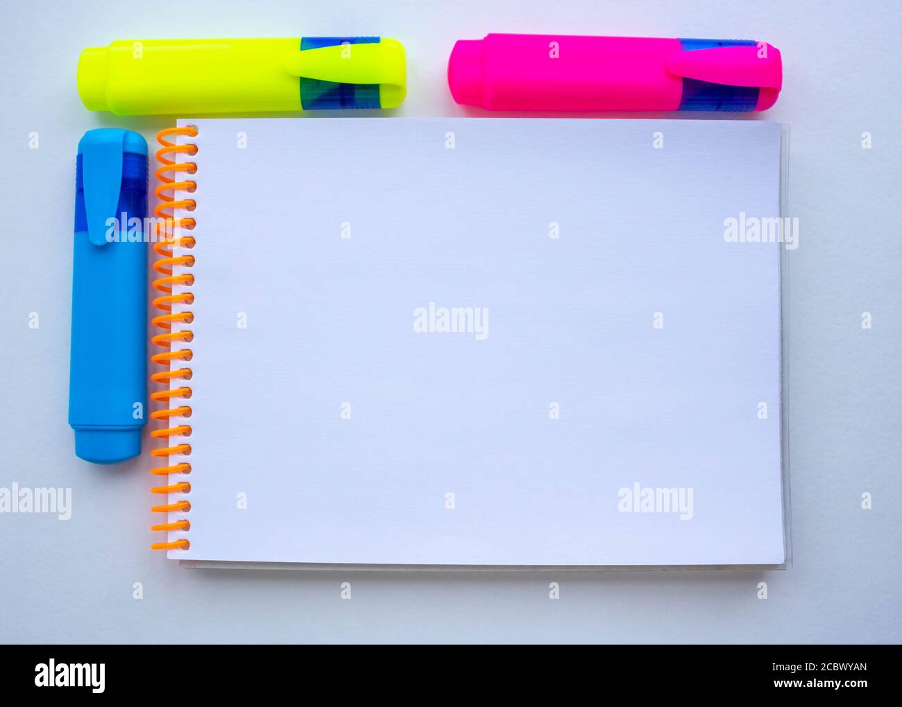 Three felt-tip pens and a Notepad with an orange spiral.School supplies ...
