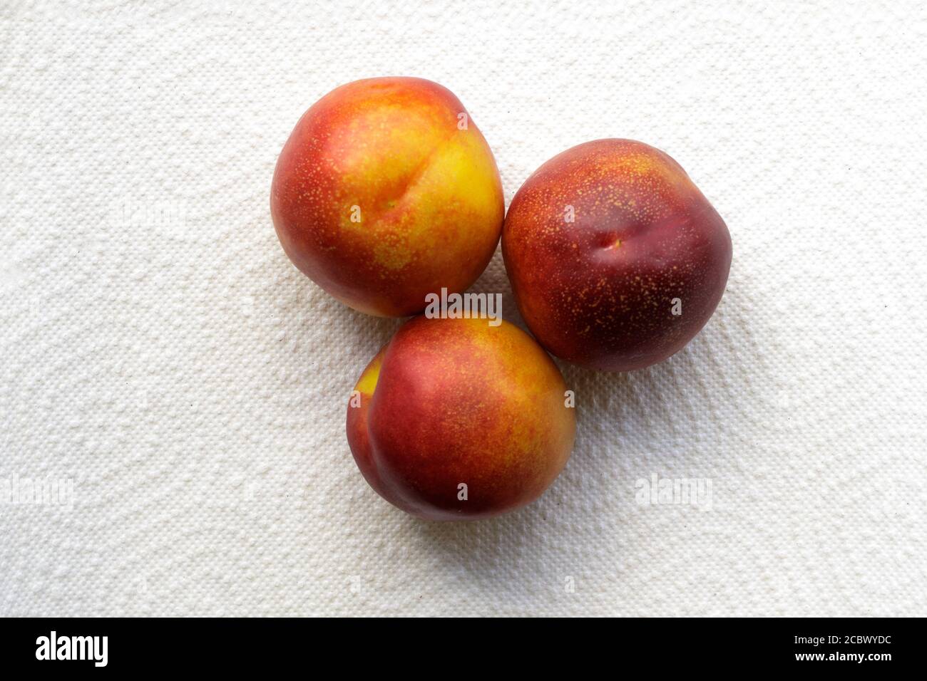 Three ripe nectarines on a white background Stock Photo - Alamy