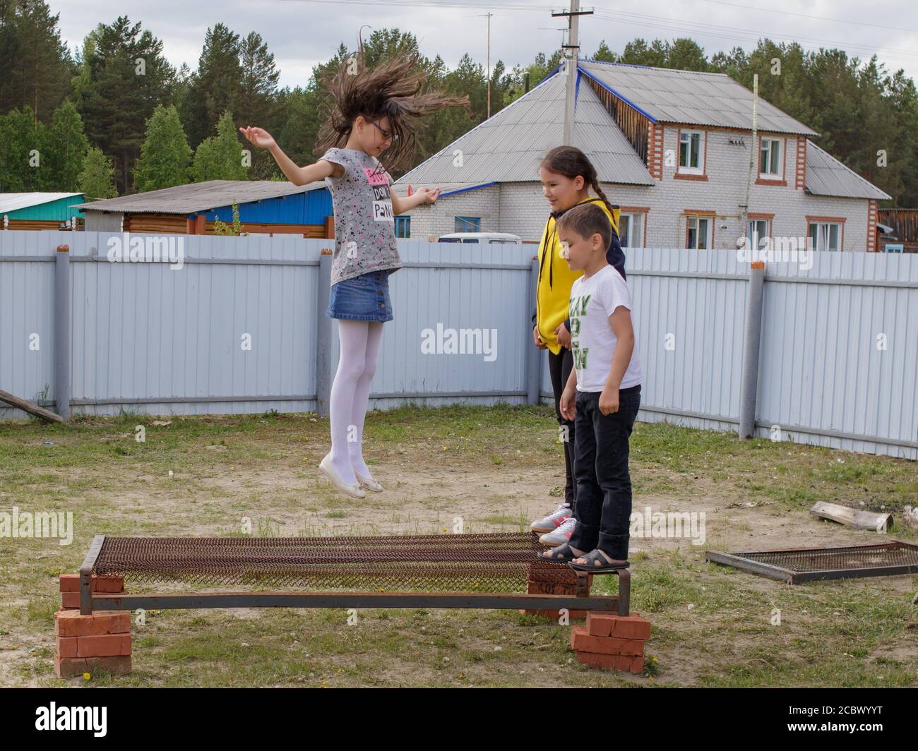 Three children play in the courtyard of a village house Stock Photo - Alamy