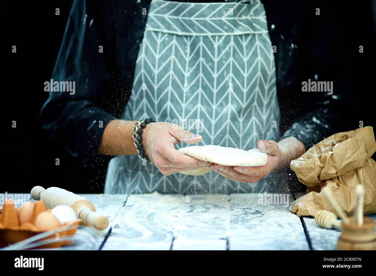 The man, chef cooks throws the dough, flying, freezing in motion ...