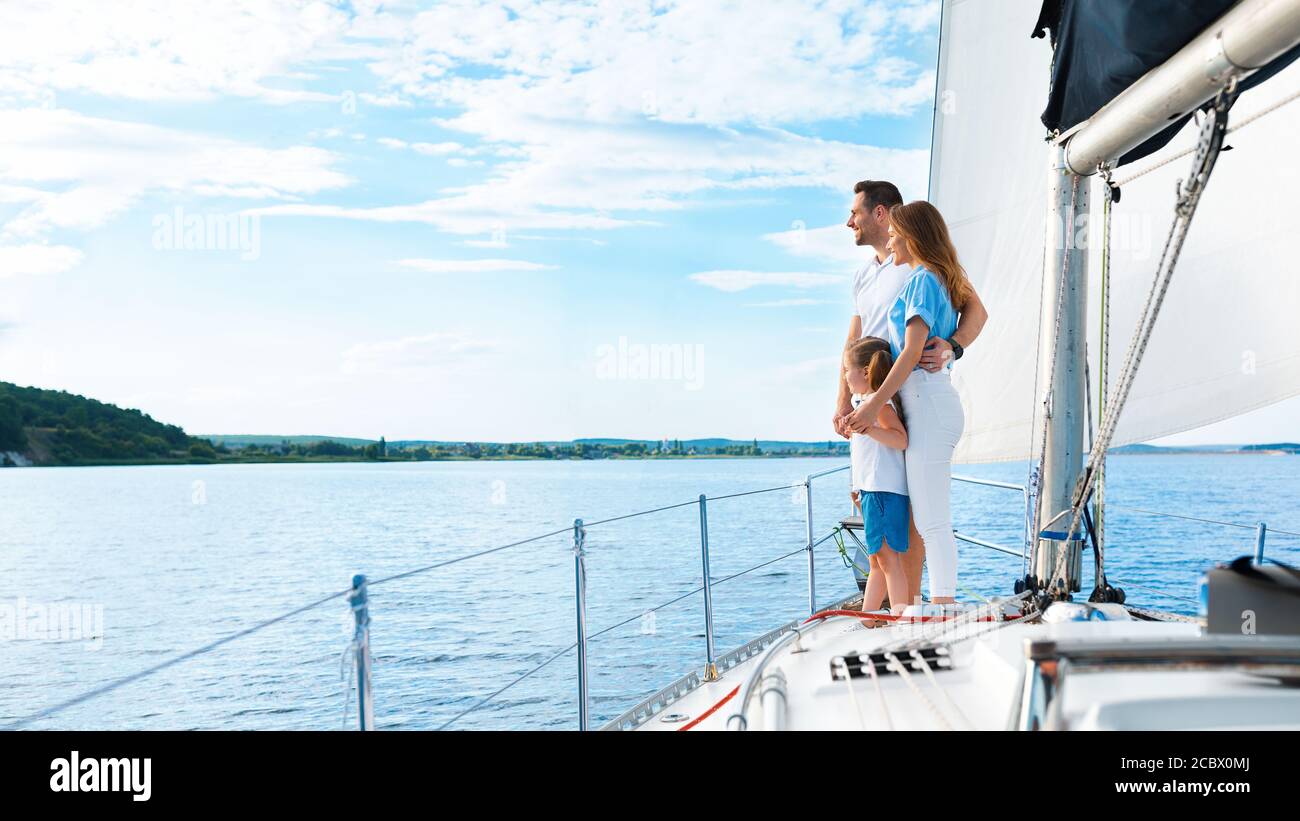 Family Of Three Enjoying Yacht Ride Standing On Boat Outdoors Stock ...