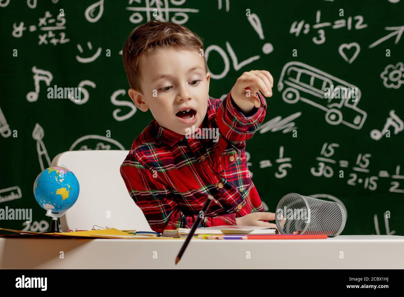 Preschooler boy making school homework. School boy with happy face ...