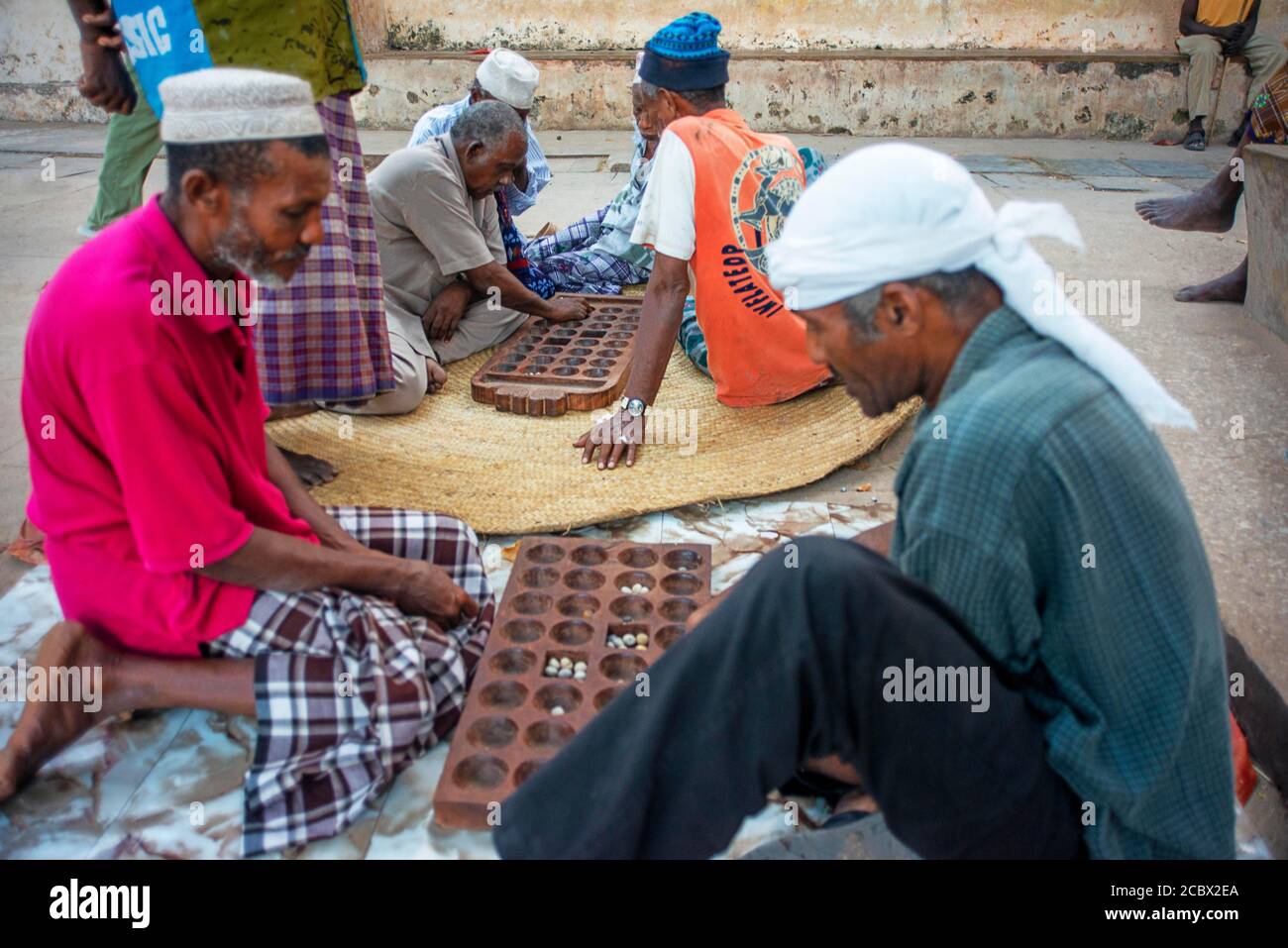 Group of Musilm men playing awale or Bao wearing traditional clothes ...