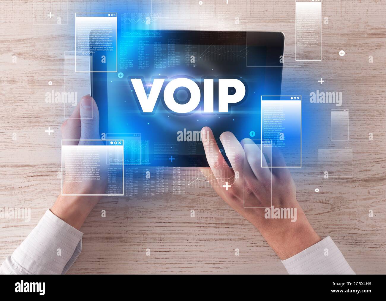 Close-up of a hand holding tablet with VOIP abbreviation, modern ...