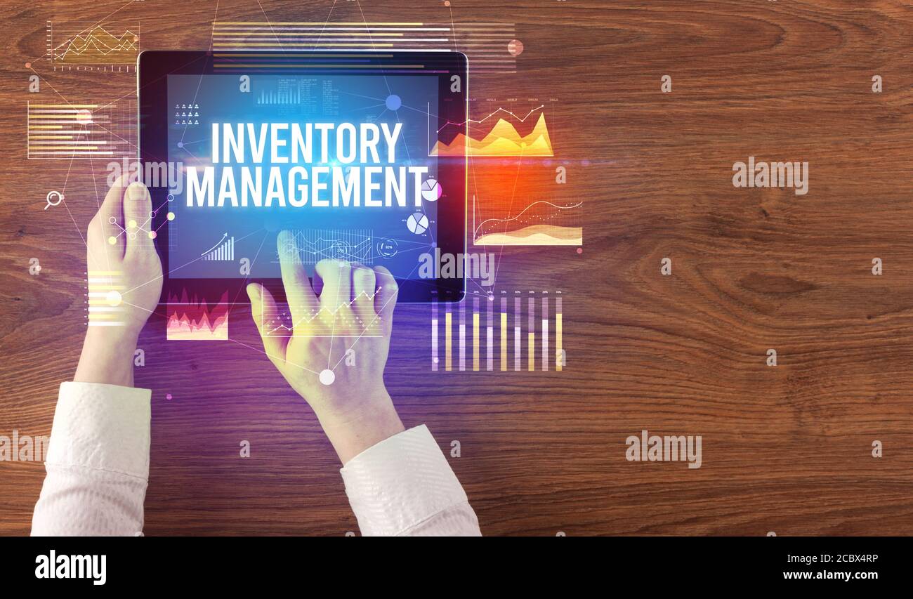 Close-up of hands holding tablet with INVENTORY MANAGEMENT inscription ...