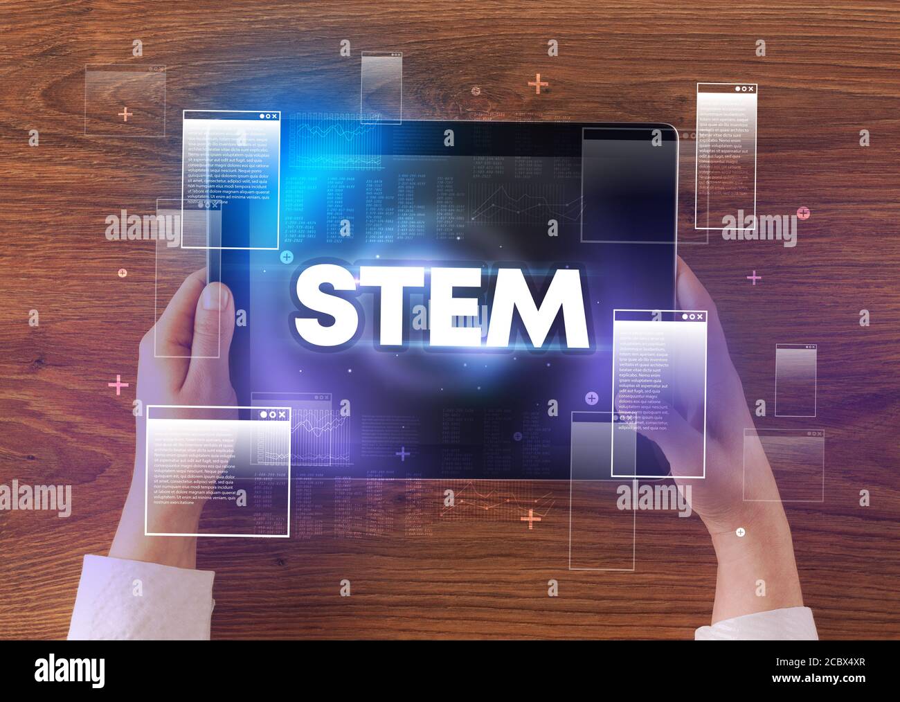 Close-up of a hand holding tablet with STEM abbreviation, modern ...