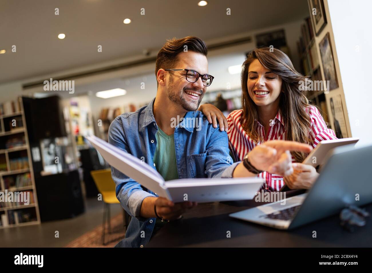 University students in cooperation at library. Group of young friends ...