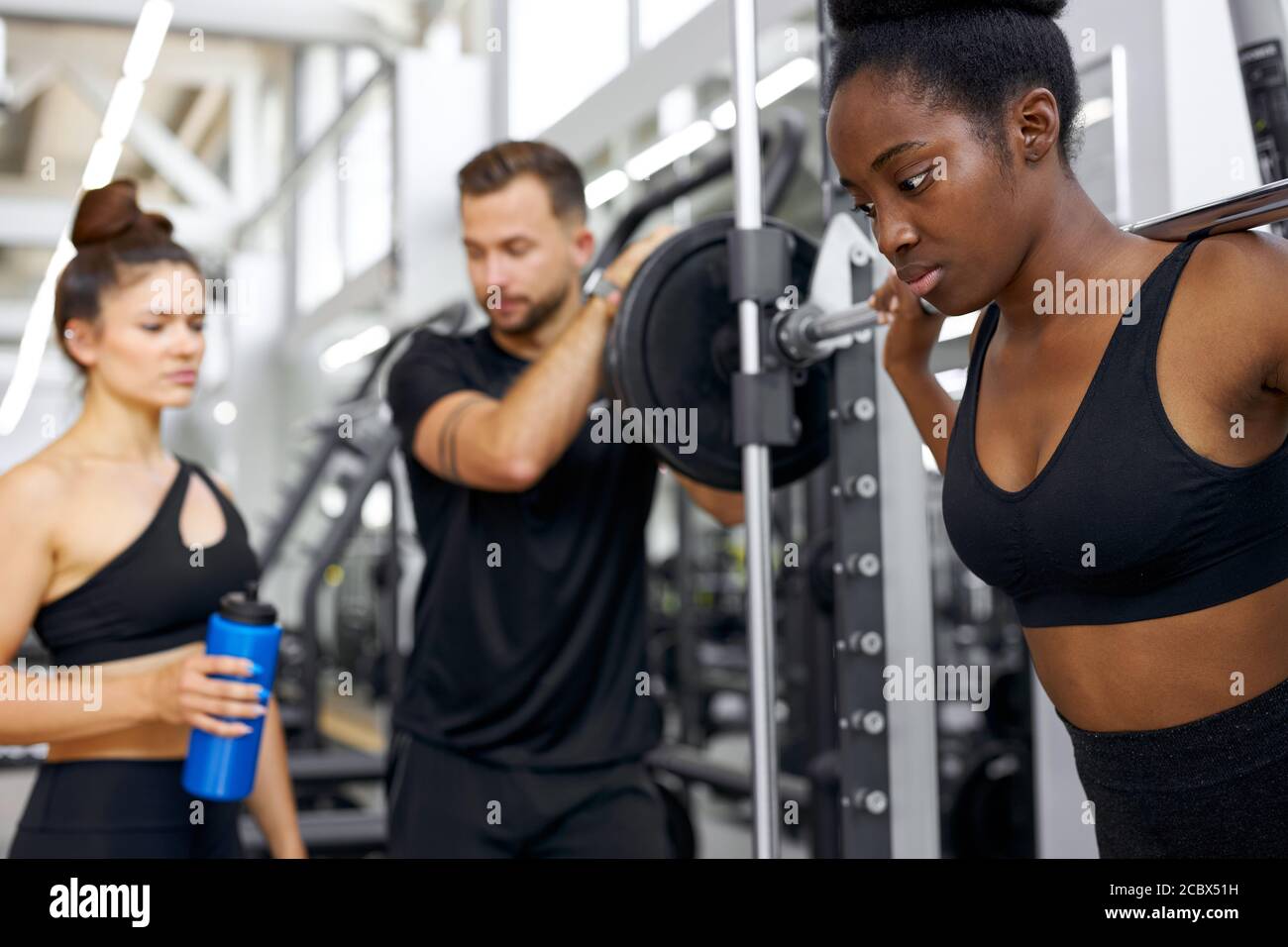 sportive people, multiethnic group perform exercises with heavy weights ...
