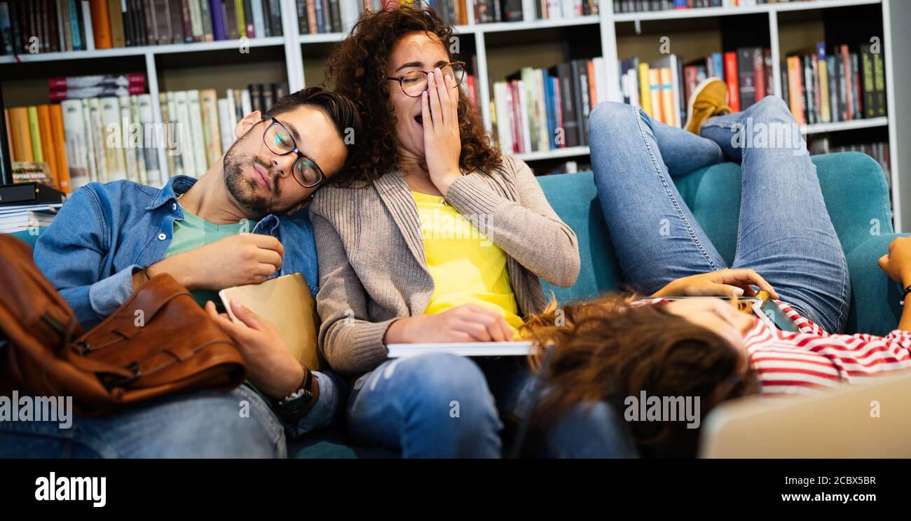 Group of young tired students studying, learning for exam in library ...