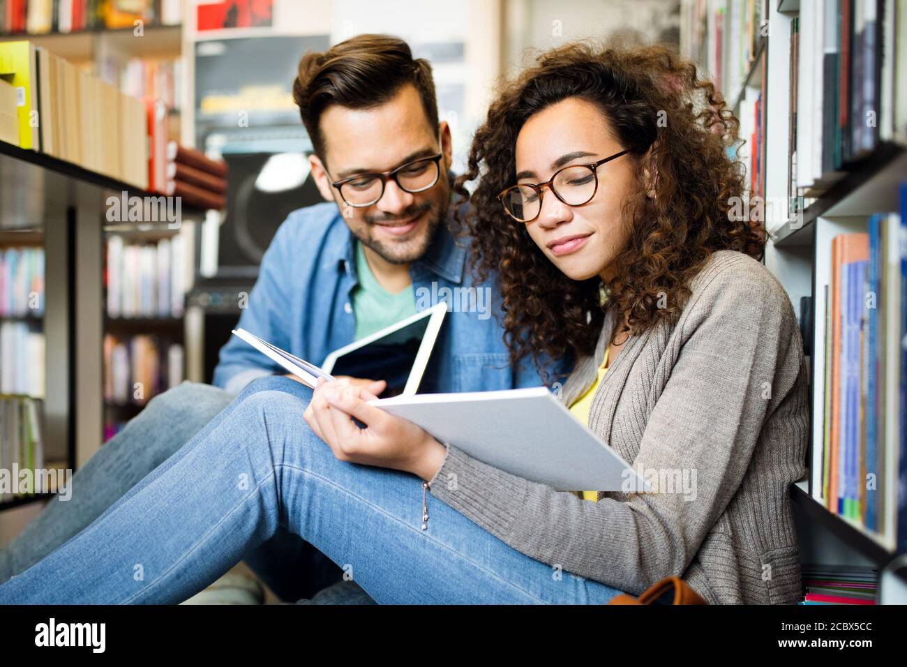 Students are studying together in library. Couple, study, technology ...