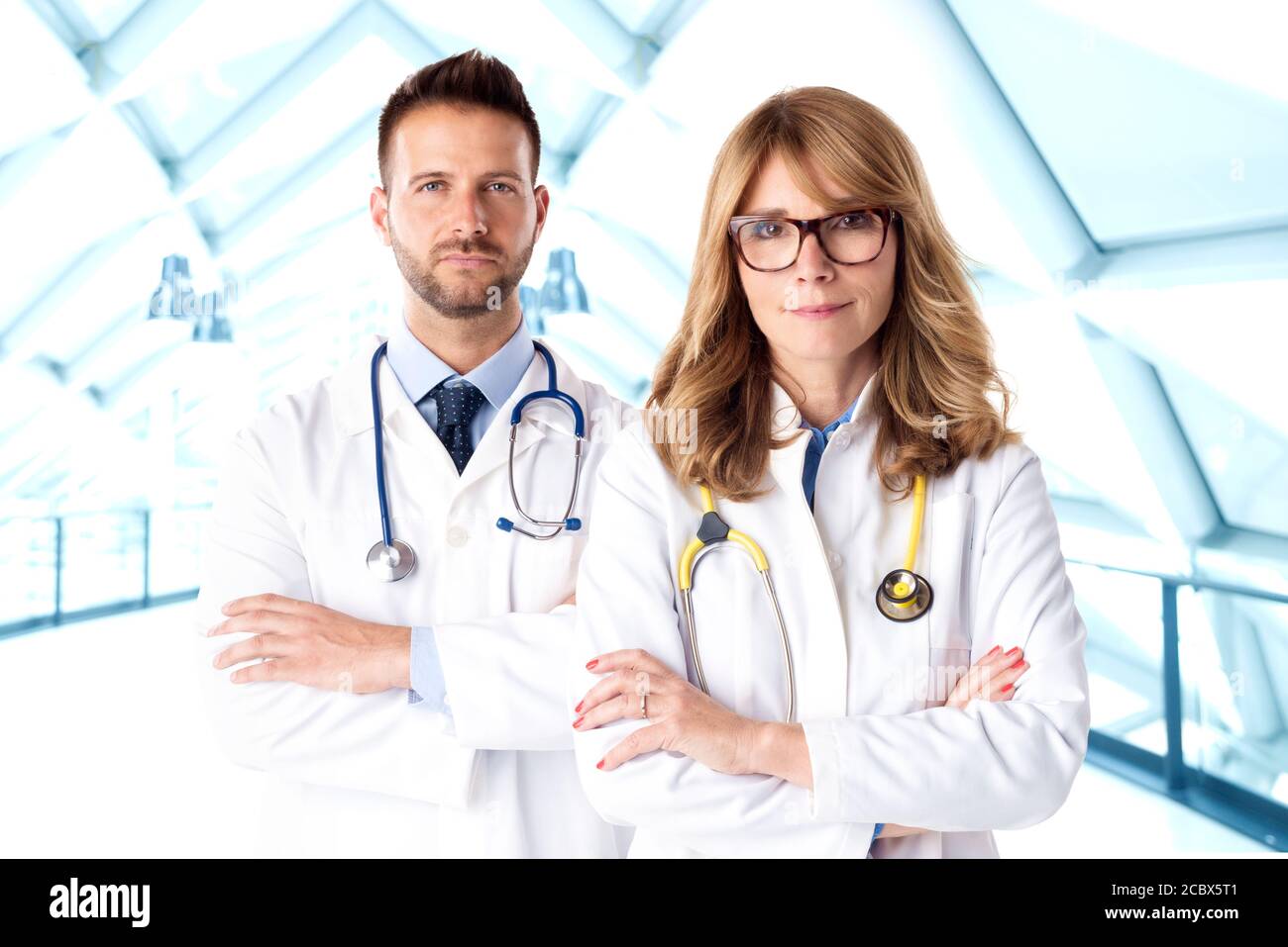 Shot of female and male doctors standing together at isolated white ...