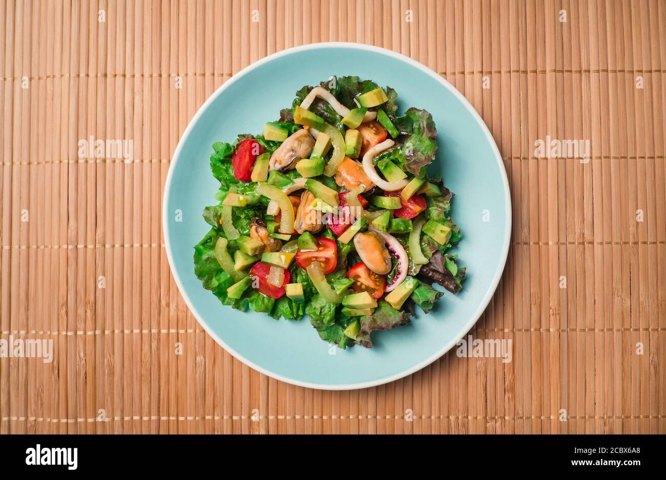 Top view - Salad with seafood on color plate Stock Photo - Alamy
