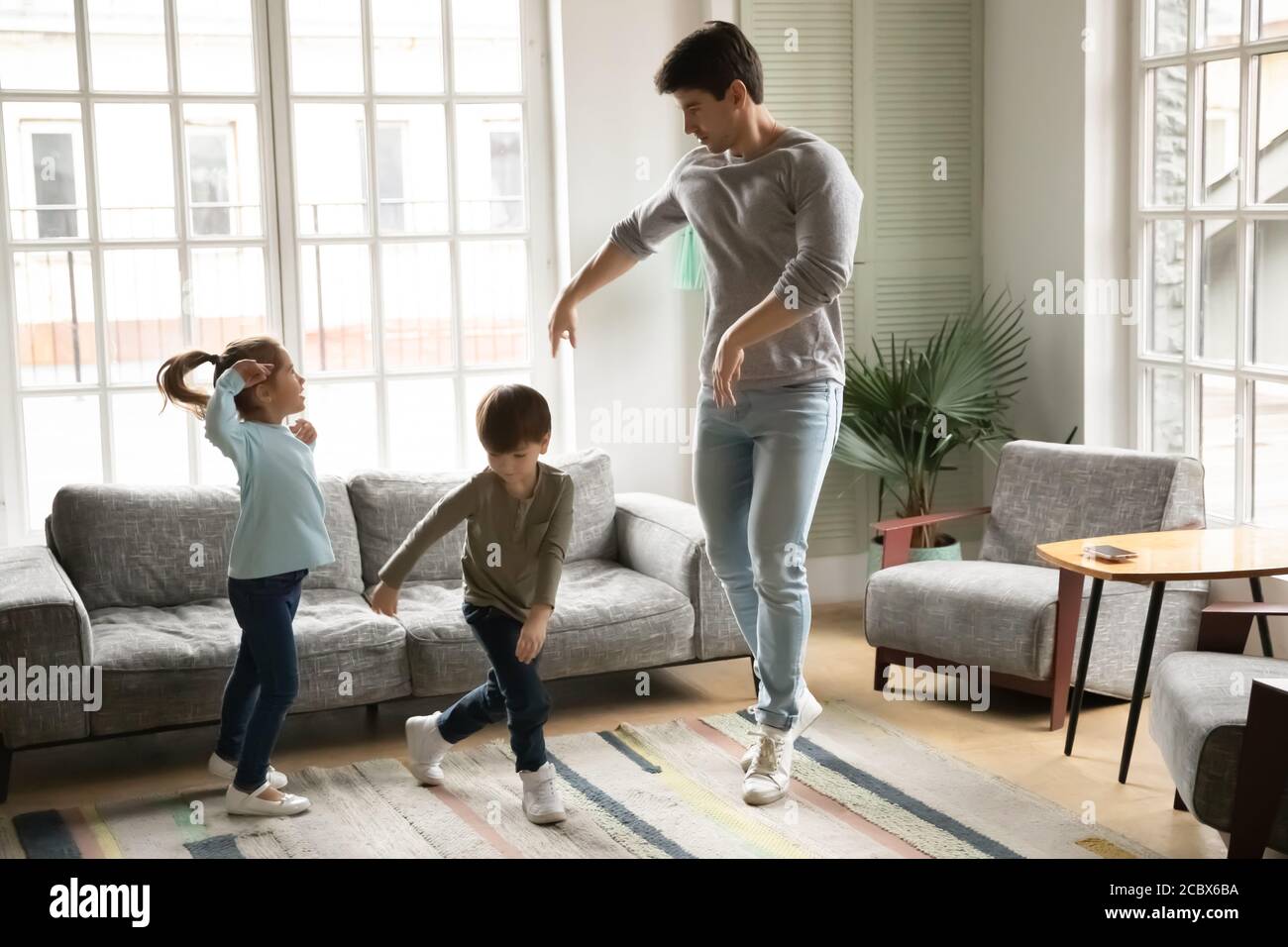 Happy family dancing to music in modern living room Stock Photo - Alamy