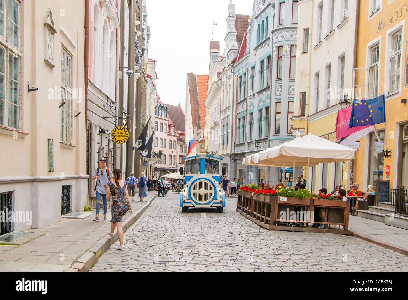 A funny blue tourist bus rides along the street of the Old Town of ...