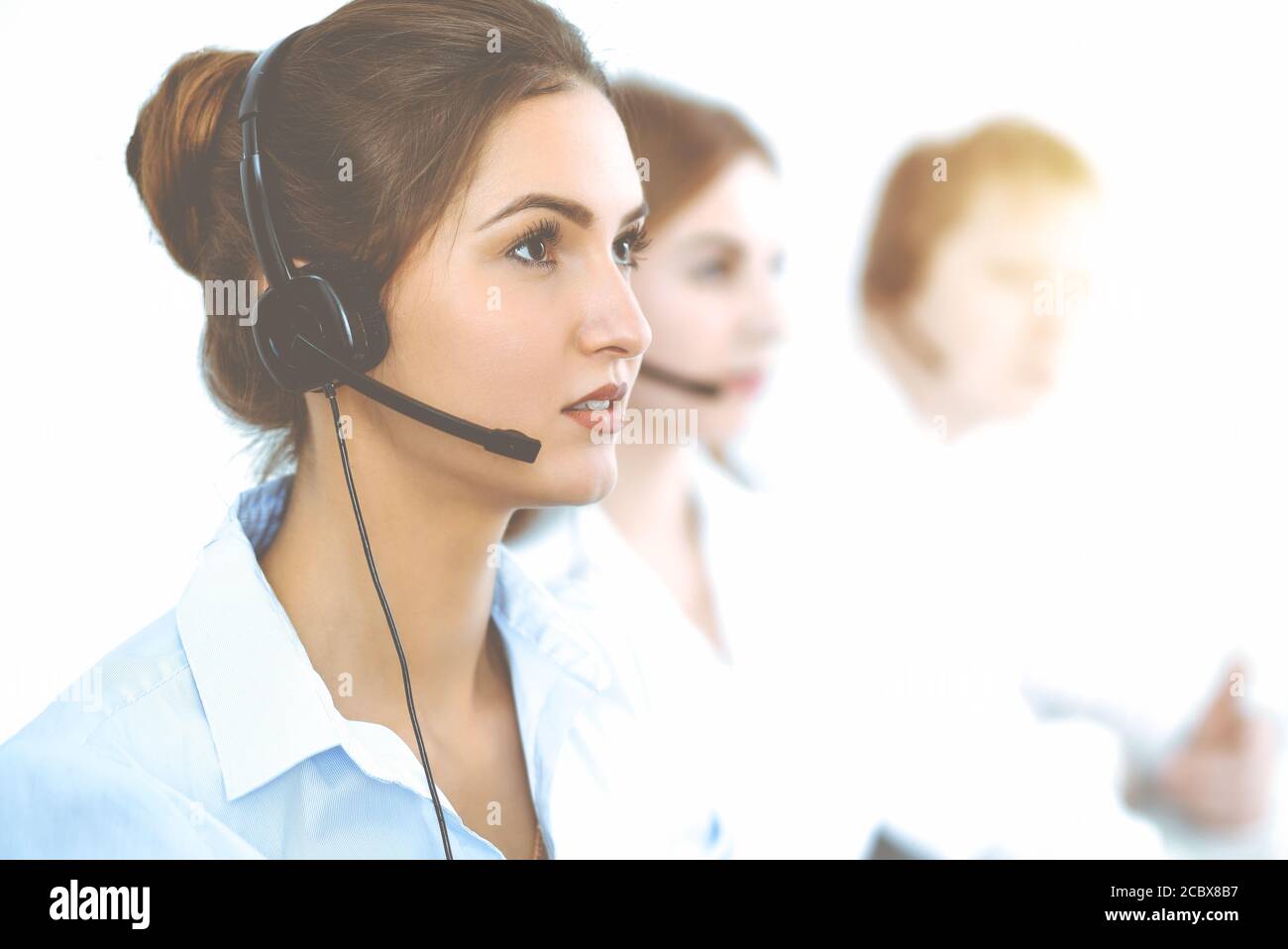 Call center. Focus on beautiful woman in headset Stock Photo - Alamy