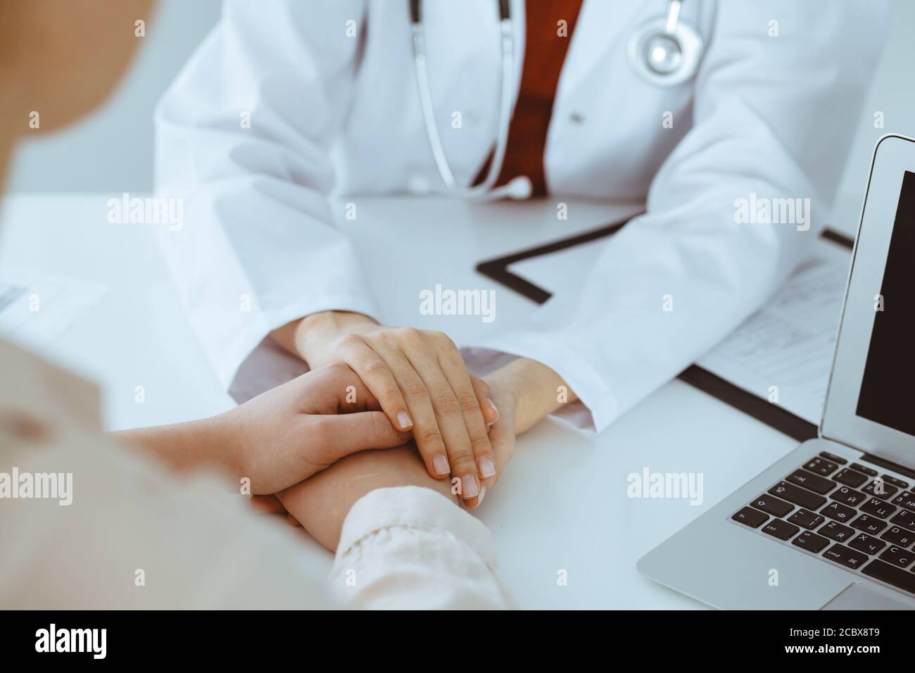 Hands of unknown woman-doctor reassuring her female patient, close-up ...