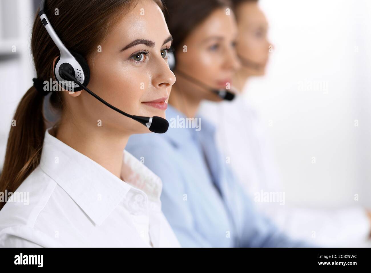 Call center. Group of operators at work. Focus on beautiful business woman in headset Stock ...