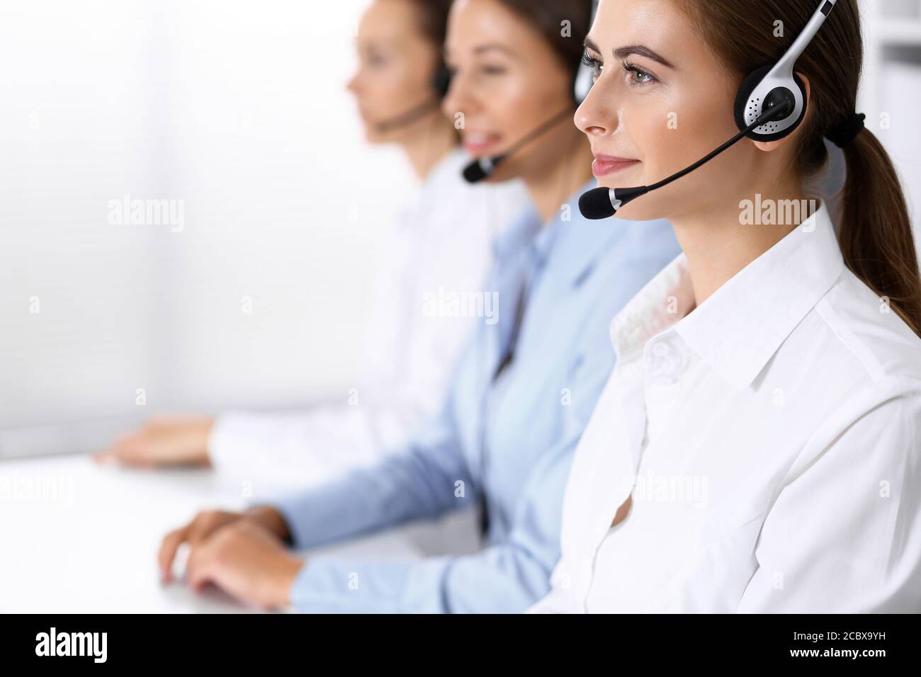 Call center. Group of operators at work. Focus on beautiful business woman in headset Stock ...