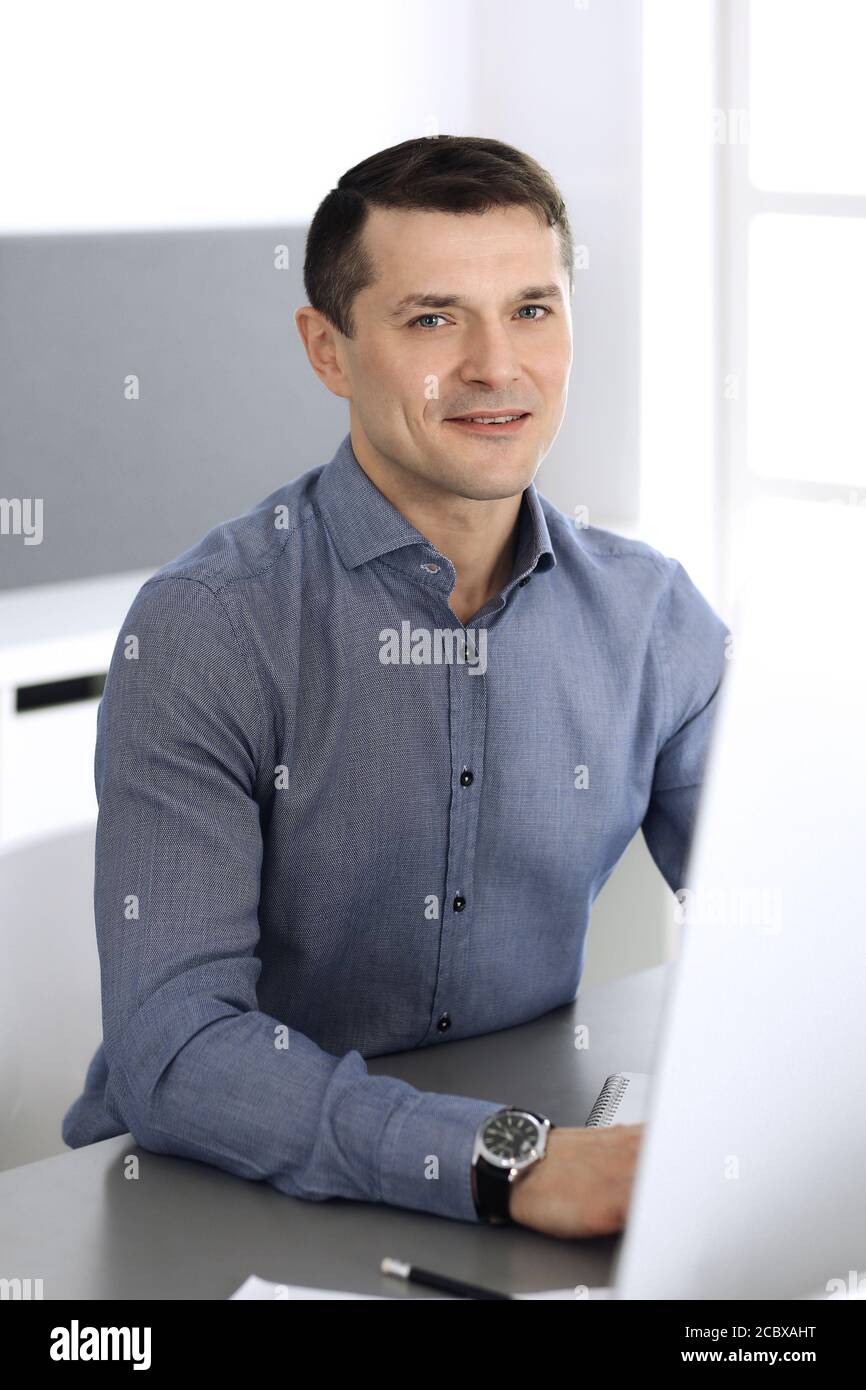 Businessman working with computer in modern office. Headshot of male ...