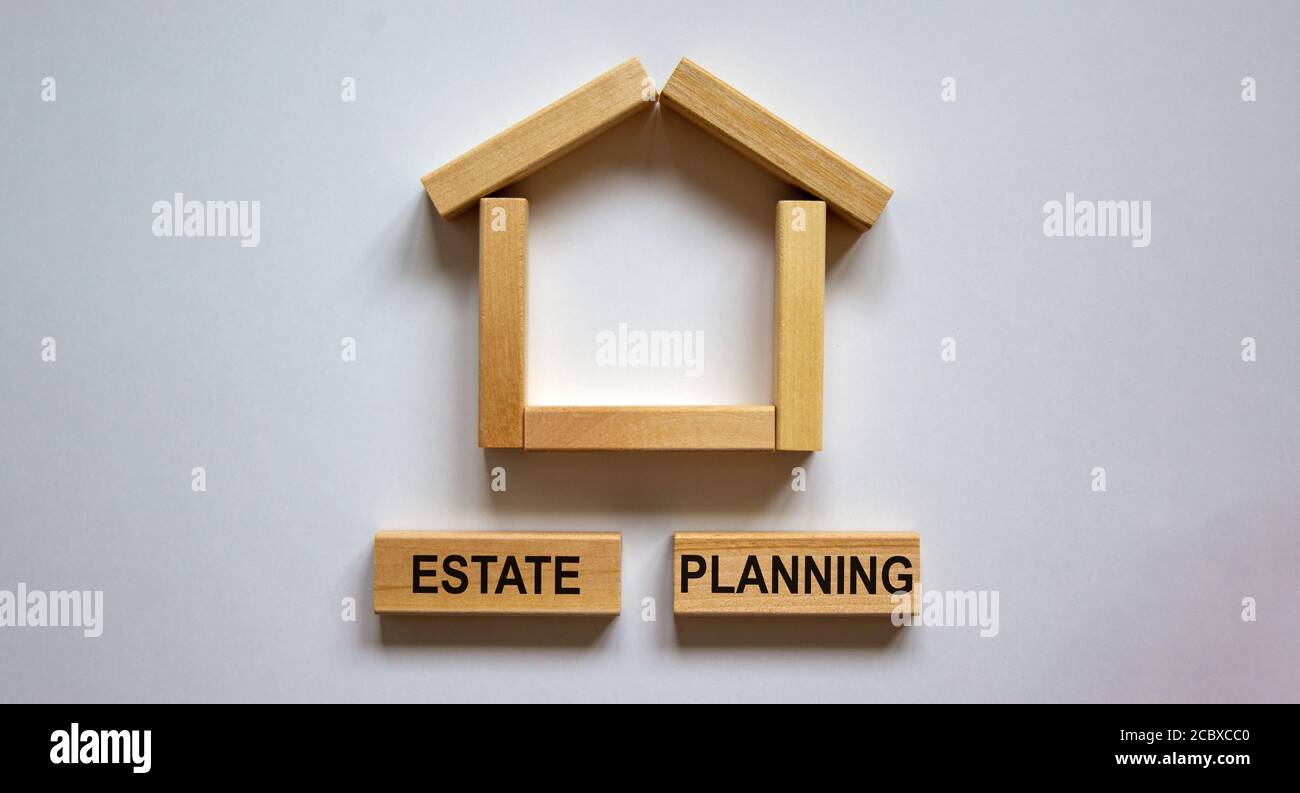 Wooden blocks form the words 'estate planning' near miniature house ...