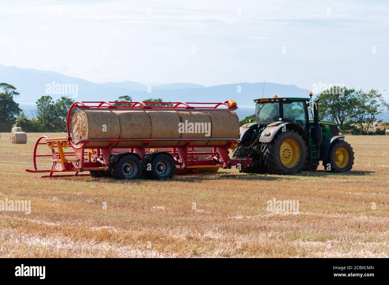 West Kilbride, Scotland, UK. 16th August 2020. A tractor towing a round ...