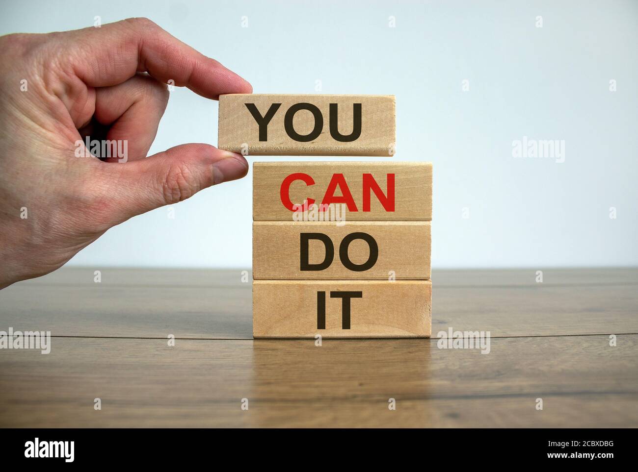 Male hand placing a block with word 'you' on top of a blocks tower with ...