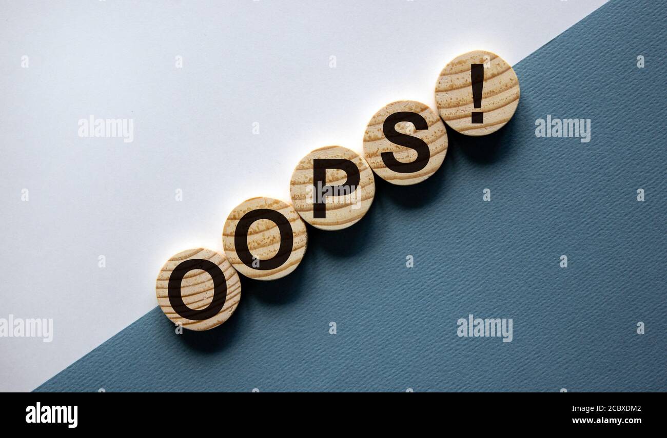 Wood circles with word 'oops' on paper white and blue background, copy ...