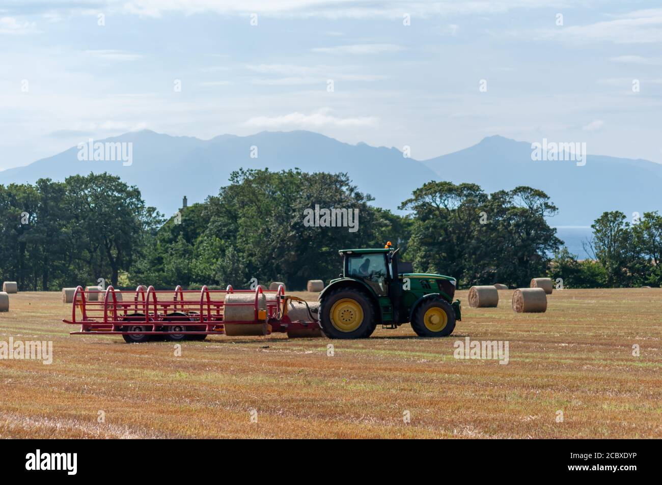 West Kilbride, Scotland, UK. 16th August 2020. A tractor towing a round ...