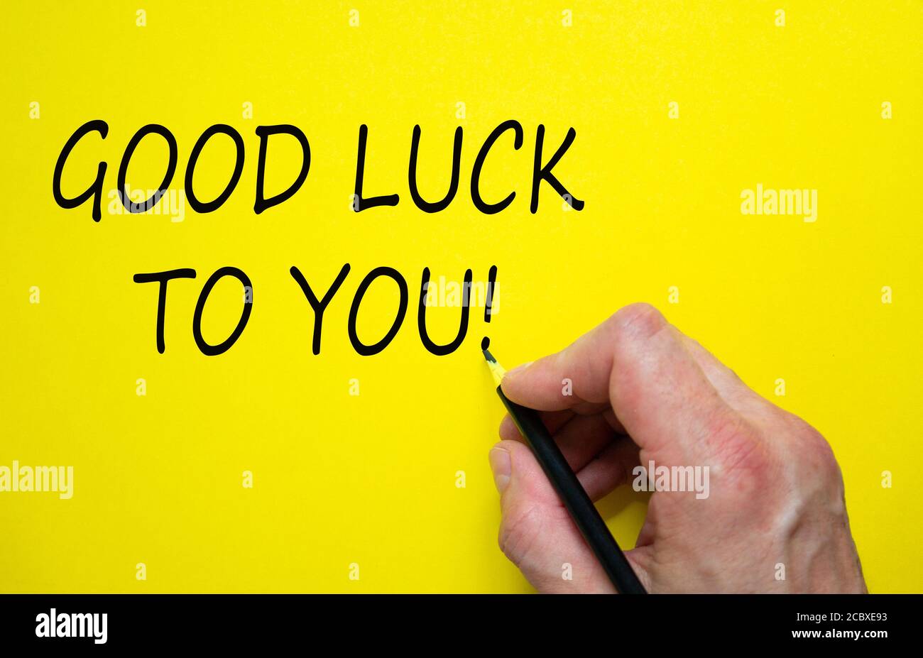 Hand writing 'good luck to you', isolated on yellow background ...
