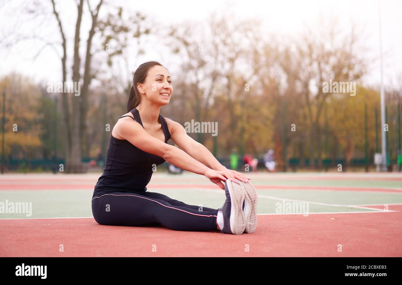 Happy girl doing fitness exercises outdoor on playground. Healthy ...