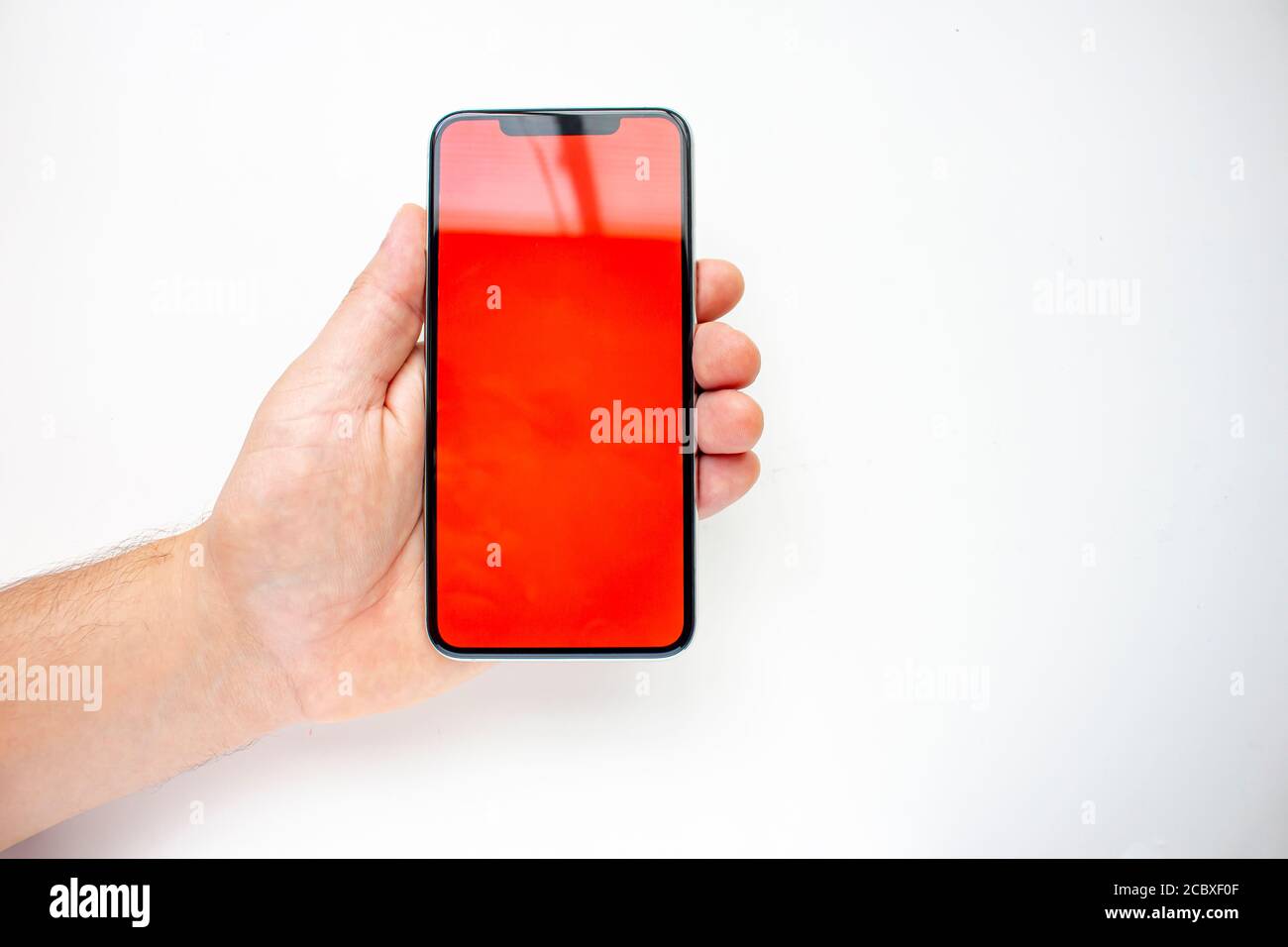 A person holding an Smart Phone with a red screen on a white background ...