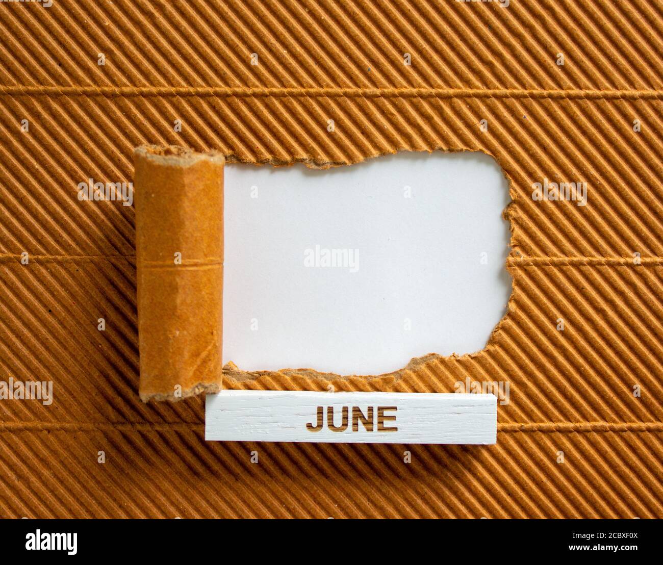 The copy space appearing behind torn brown paper. White wooden block ...
