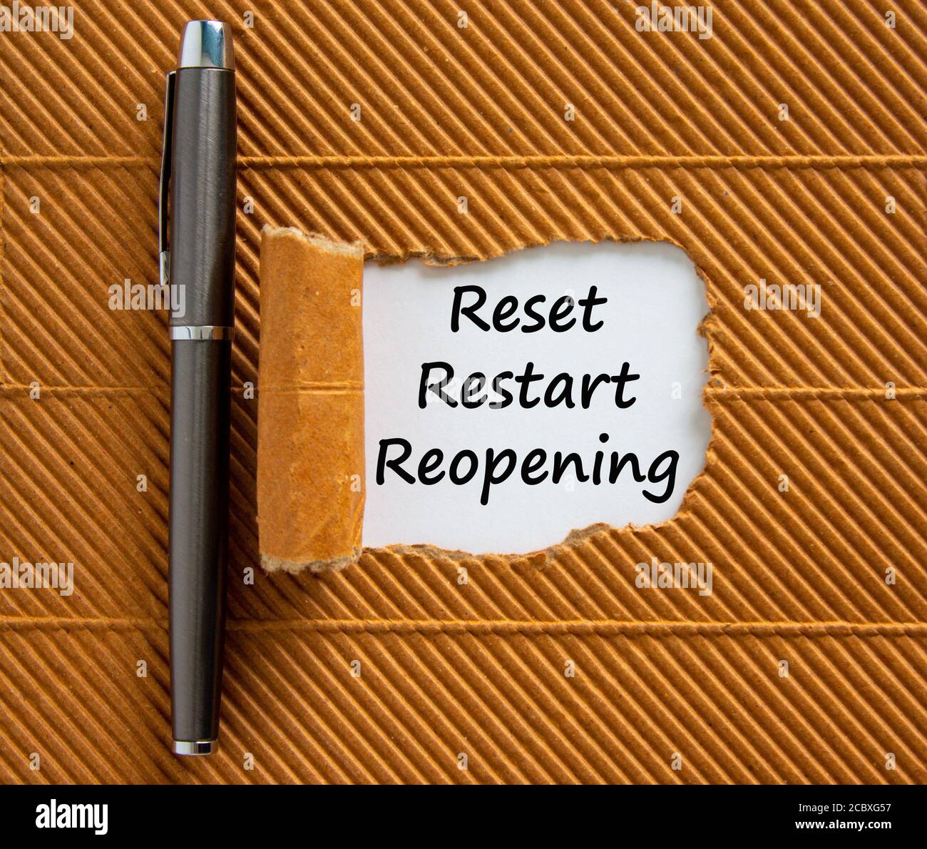 The text 'reset, restart, reopening' appearing behind torn brown paper ...