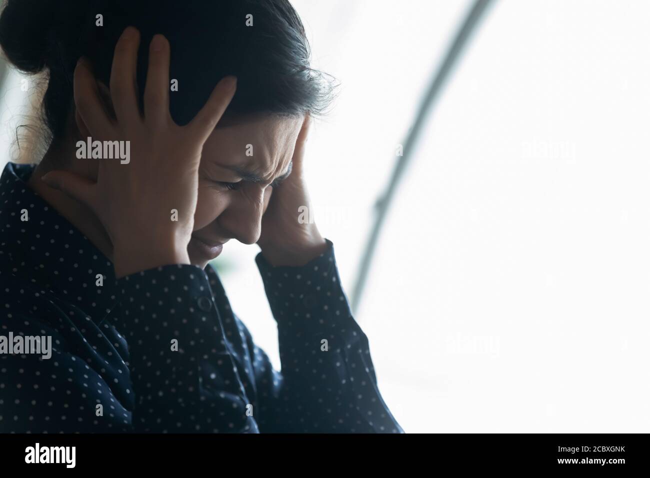 Stressed young indian ethnicity businesswoman suffering from head ache ...