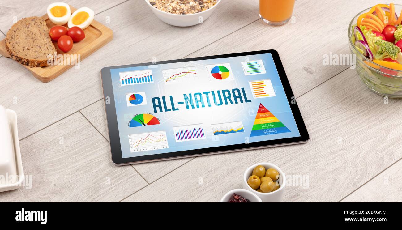Organic food and tablet pc showing ALL-NATURAL inscription, healthy ...