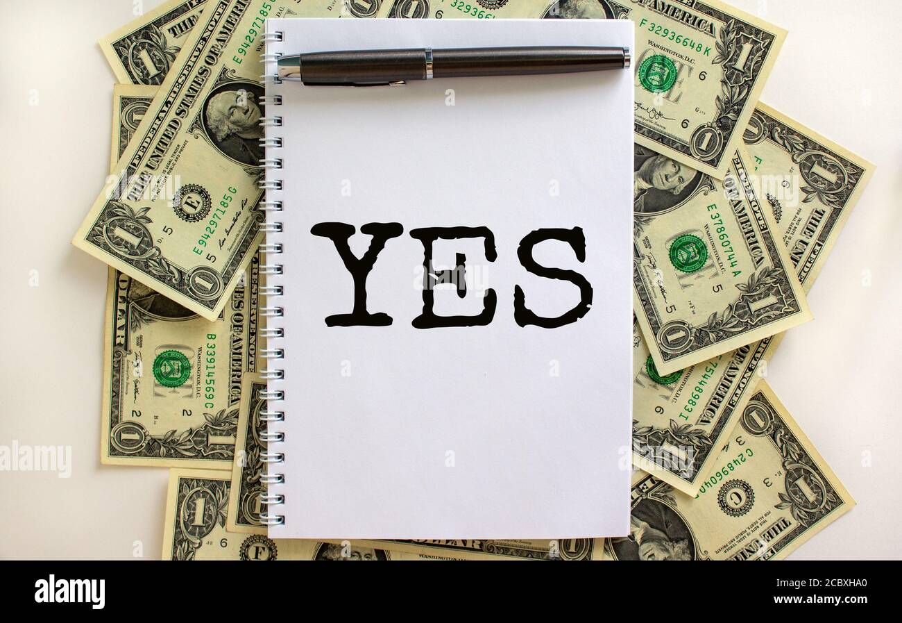 White note with word 'yes' on beautiful background from dollar bills ...