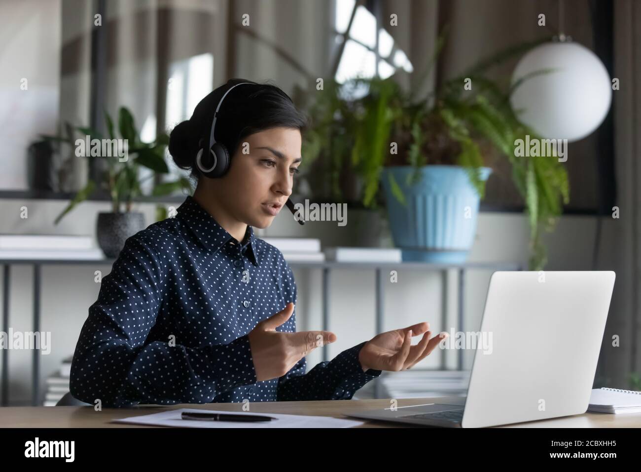 Serious mixed race woman involved in practicing foreign language online ...