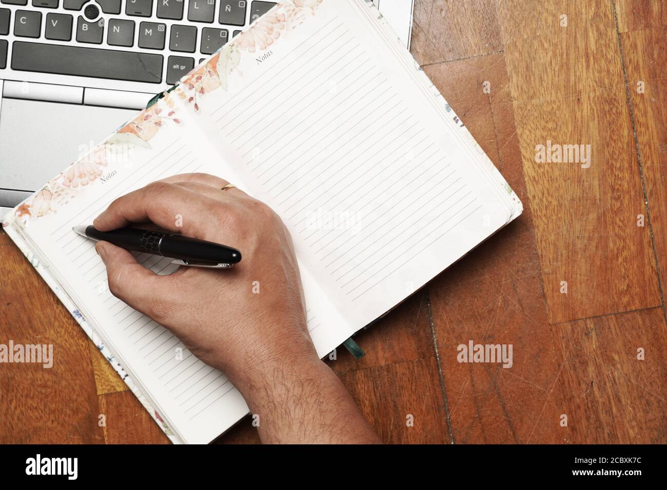 work table with man's hand writing on agenda with laptop. flat lay ...