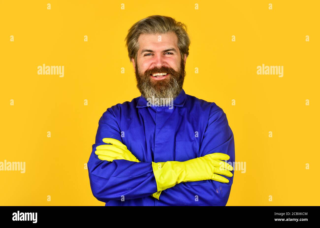 happy and ready. mature janitor in uniform yellow background. spring ...