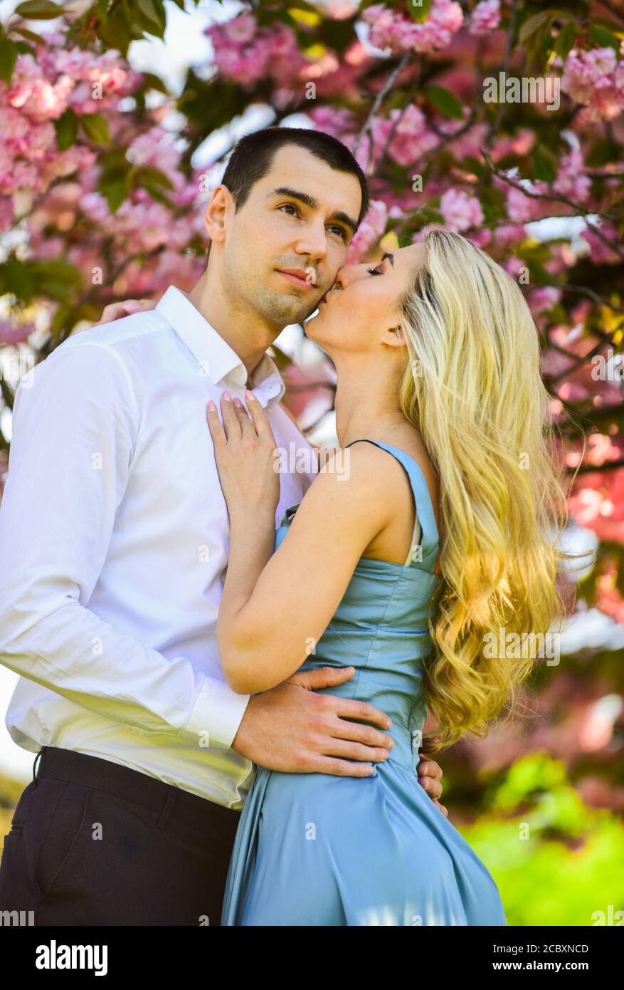 We love kissing. spring flower bloom. man and woman in park with pink ...