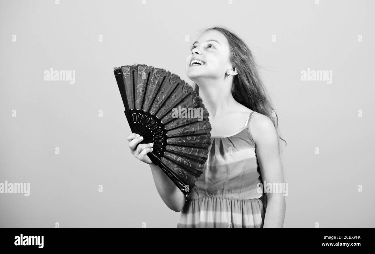 Cooling and ventilation. Summer heat. Fresh air. Kid girl fanning ...