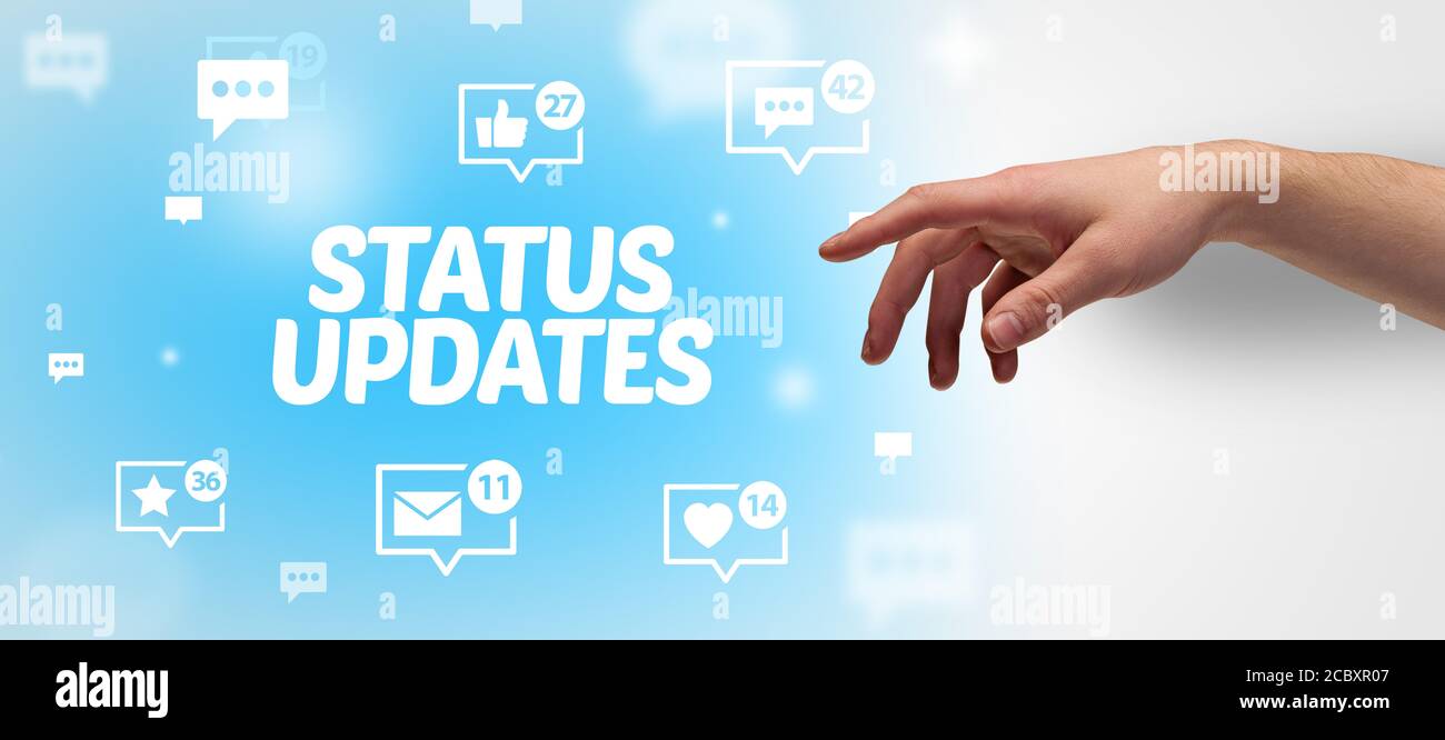 Close-Up of cropped hand pointing at STATUS UPDATES inscription, social ...