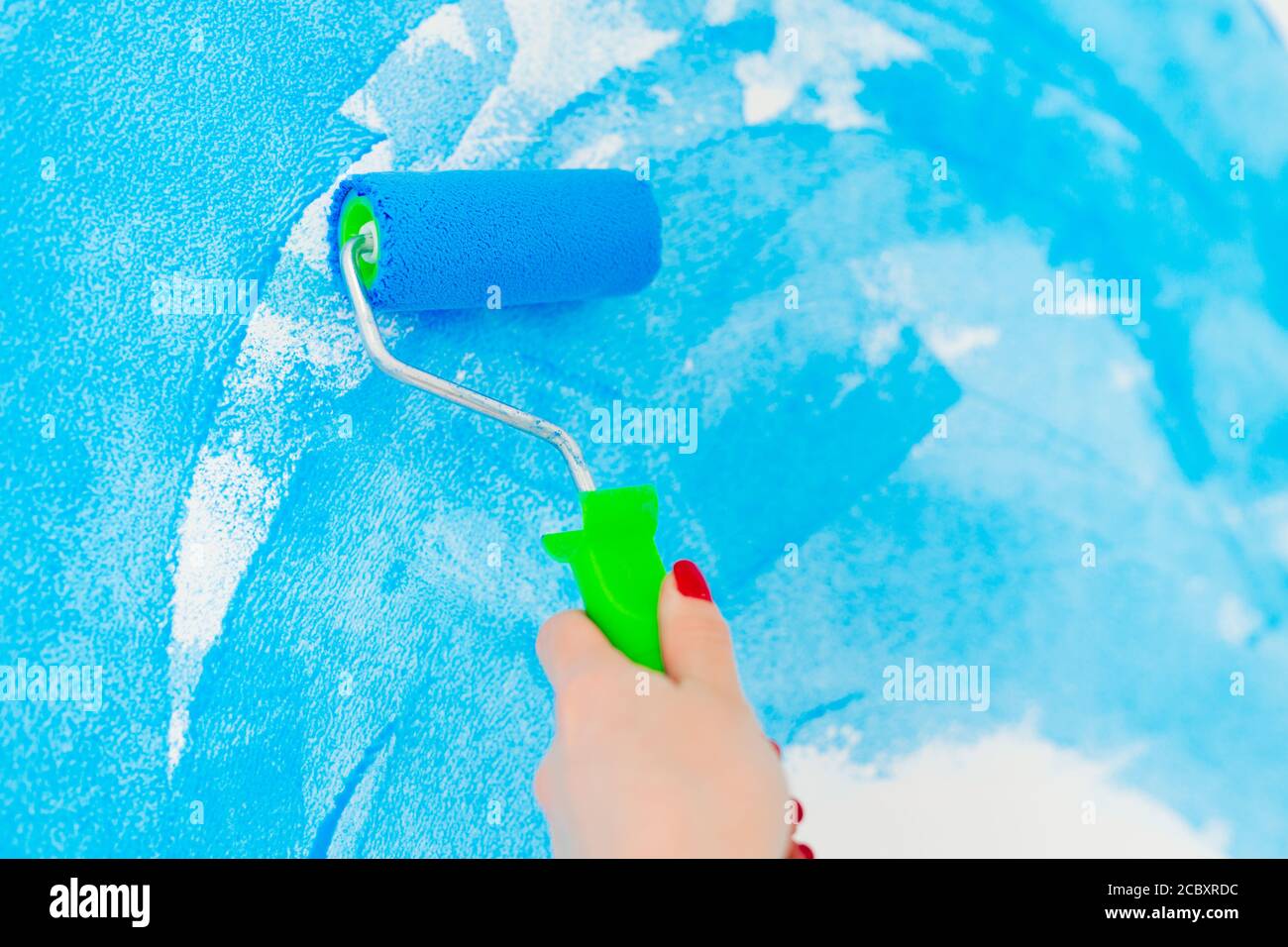 blue color painting wall with roller in hand Stock Photo - Alamy