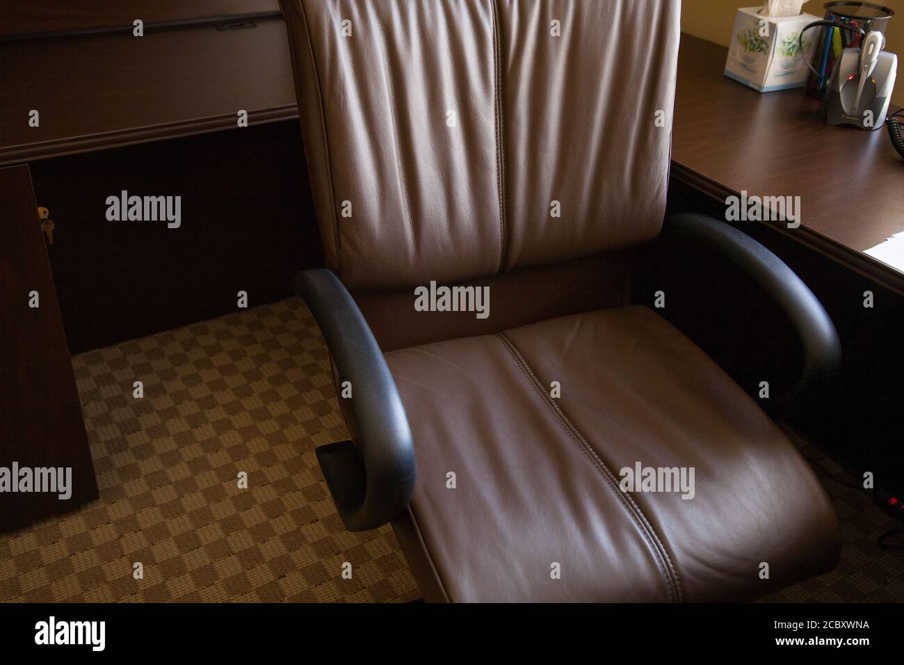 Brown leather empty office chair in office Stock Photo - Alamy