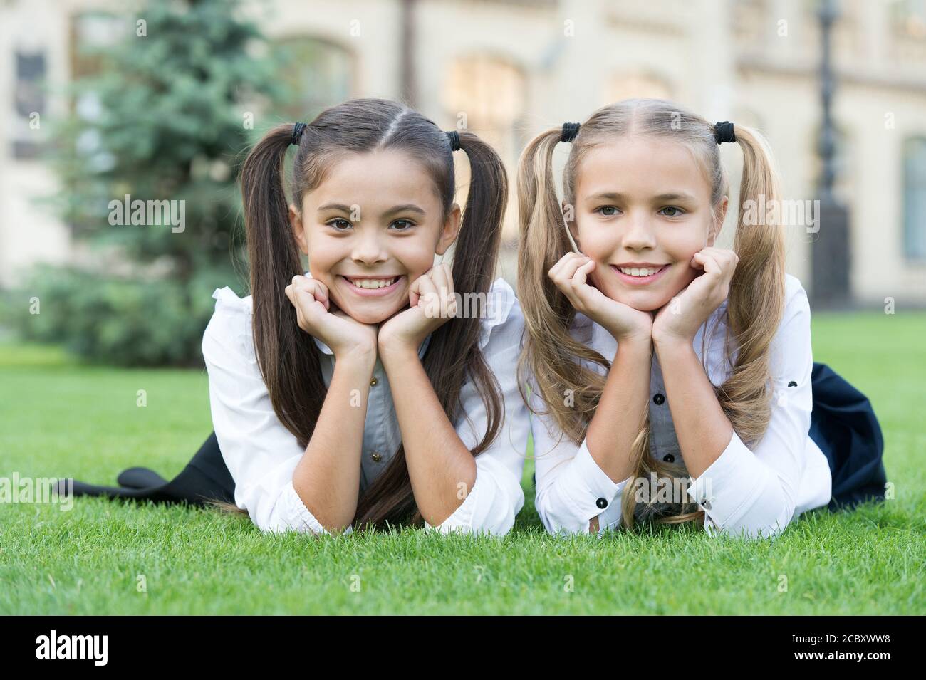 School friends formal clothes relaxing on green grass, informal ...