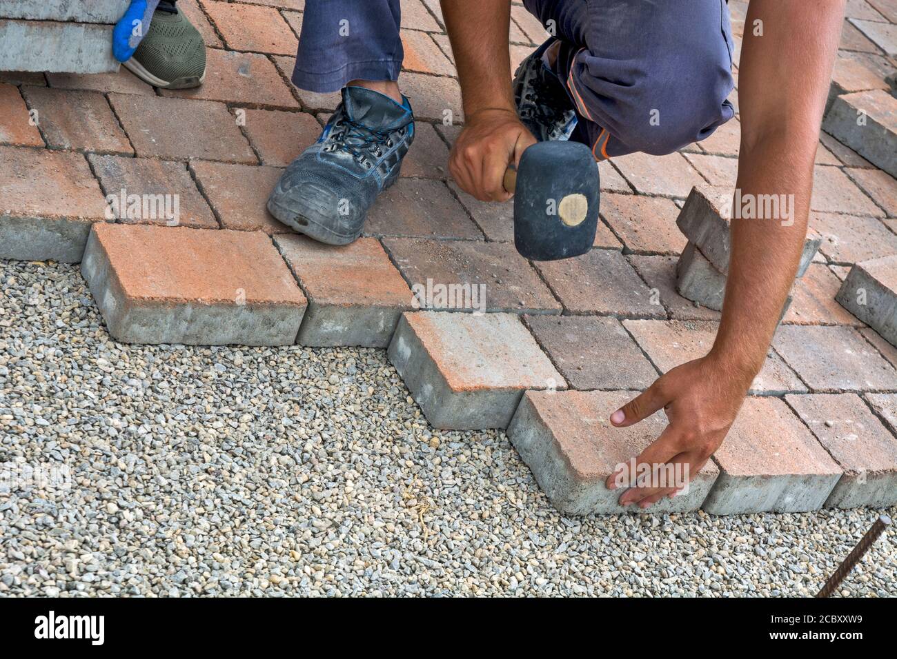 Master lay and install floor bricks on a public surface. The base is ...