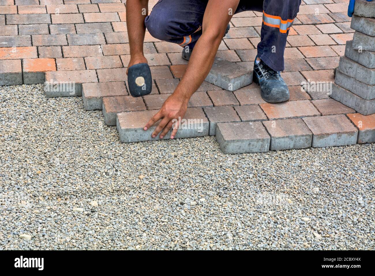 Master lay and install floor bricks on a public surface. The base is ...