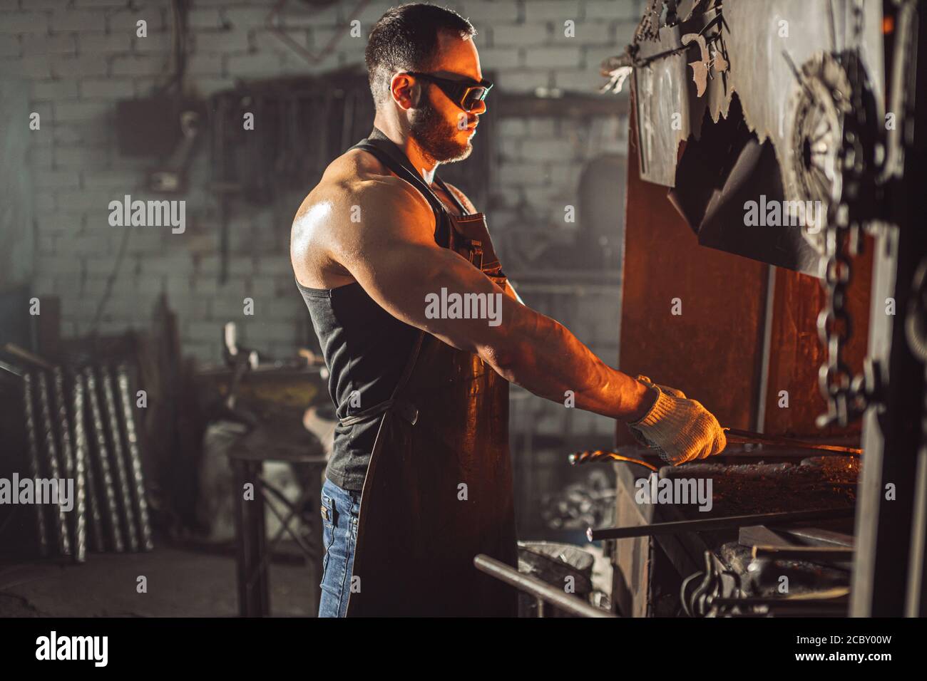 young caucasian powerful blacksmith man with muscular hands, stand ...