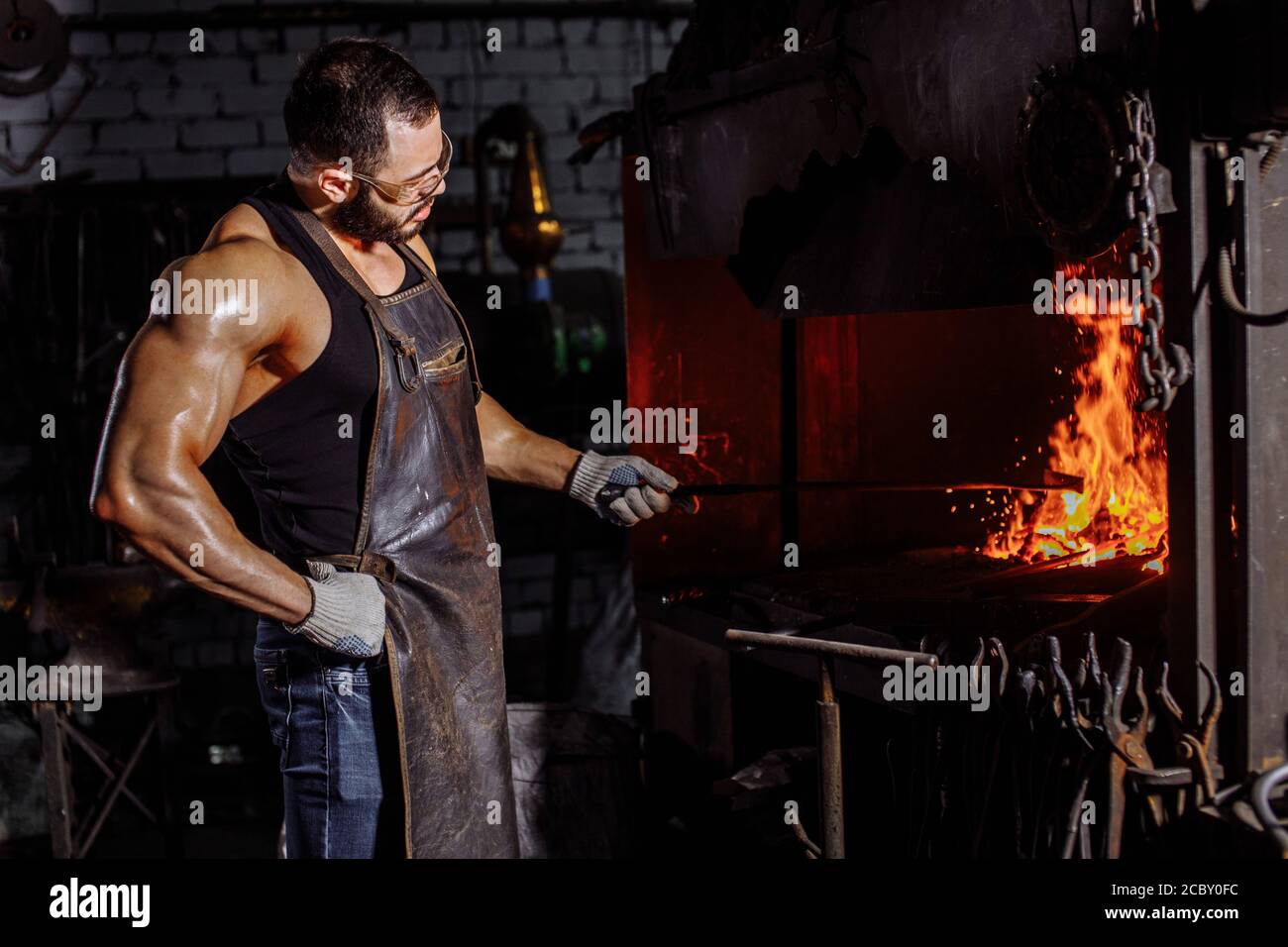 young caucasian powerful blacksmith man with muscular hands, stand ...