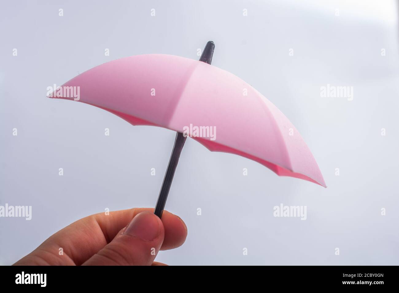 Hand holding small umbrella hi-res stock photography and images - Alamy